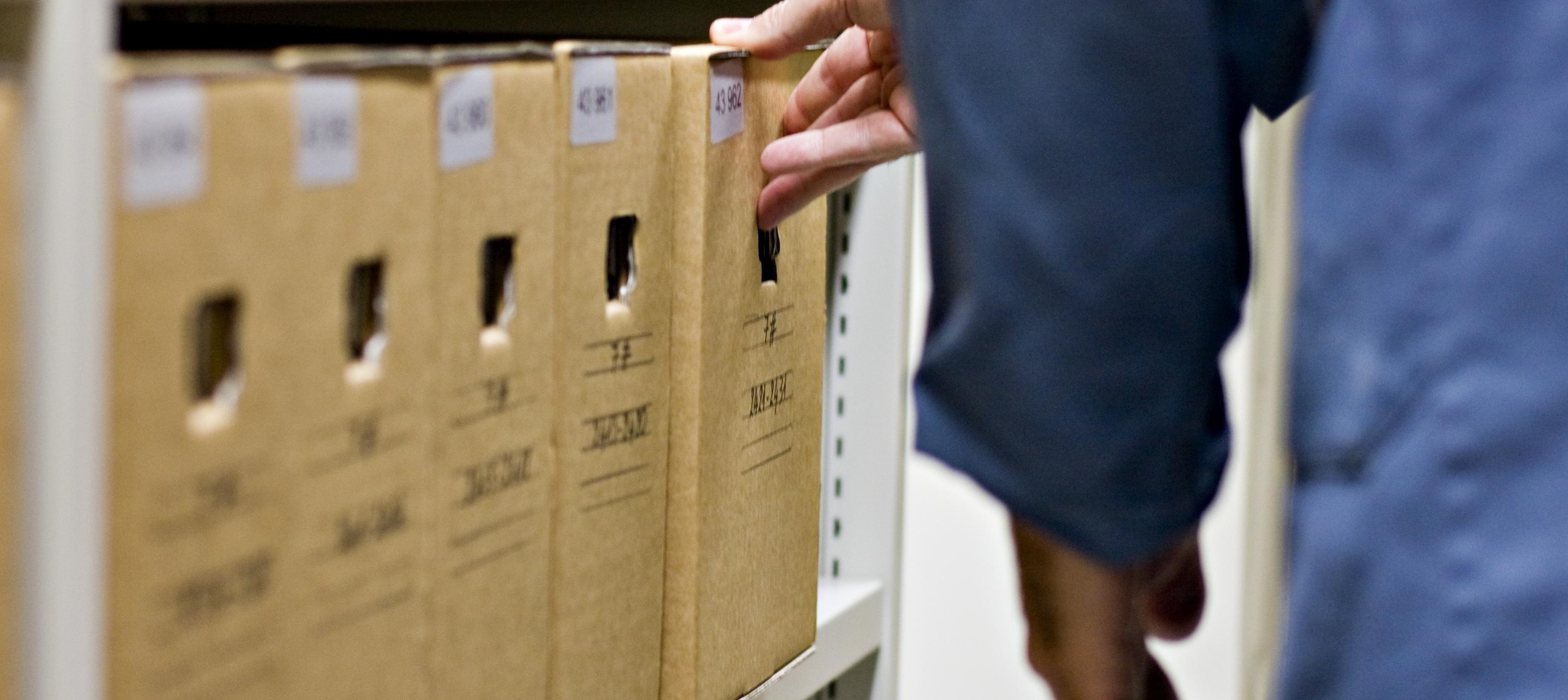 Logistiek medewerker neemt archiefdoos uit rek